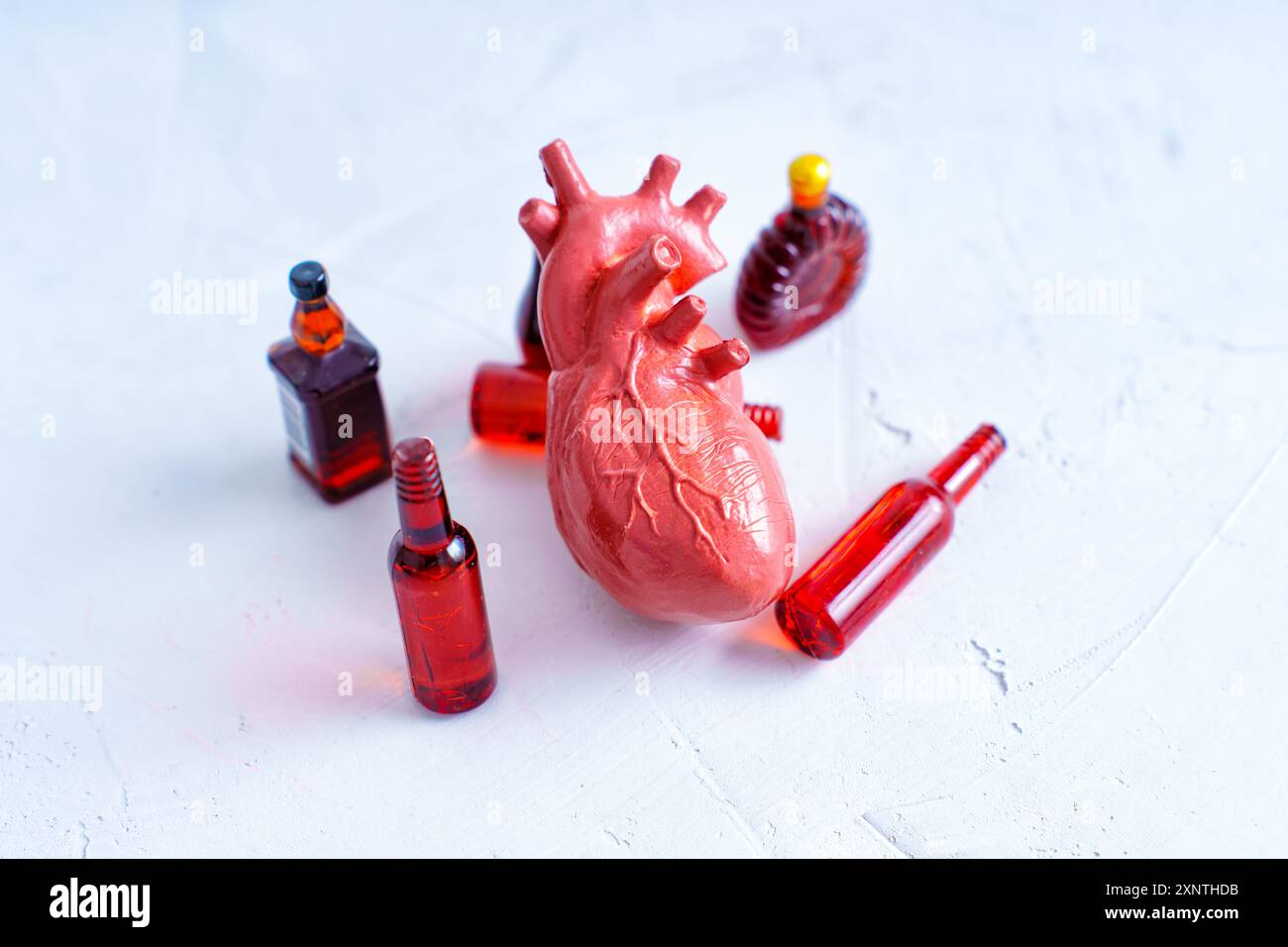 Detailed human heart model surrounded by various liquor bottles in red ...