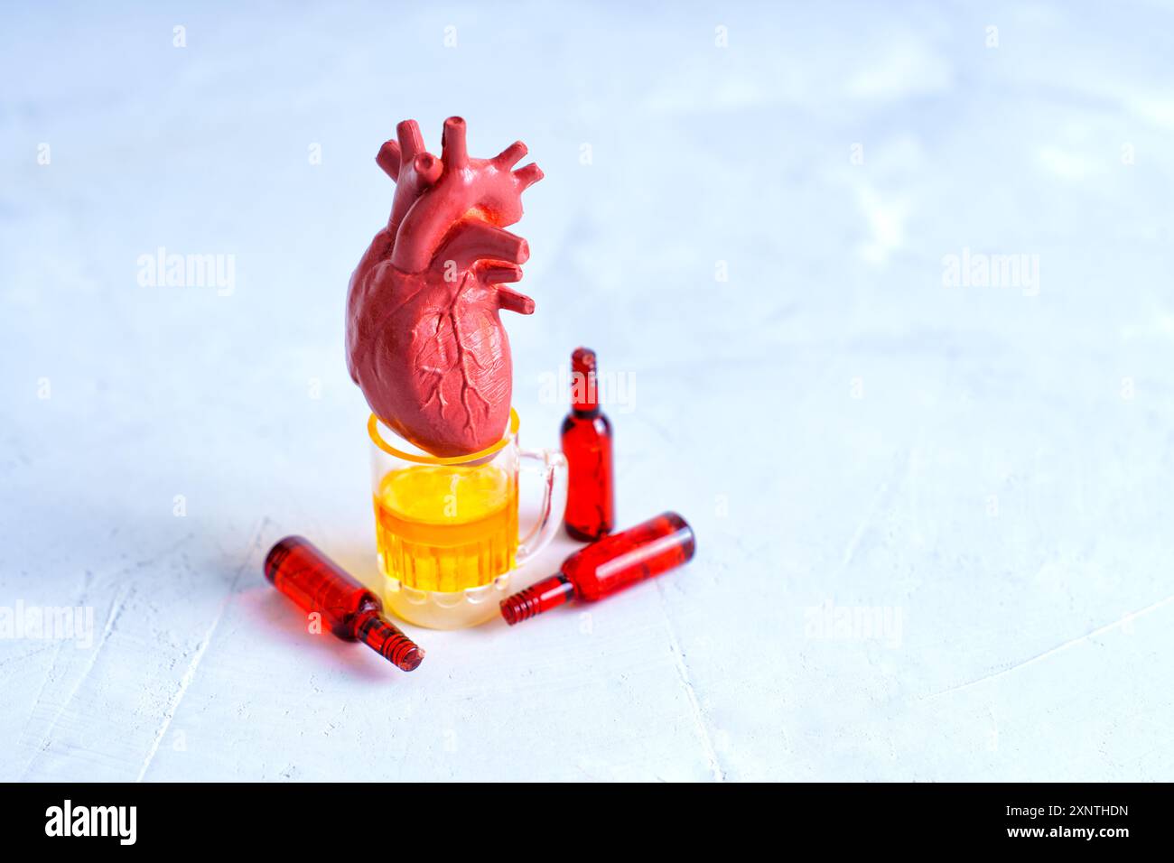 Realistic model of a human heart placed on a beer mug, surrounded by ...