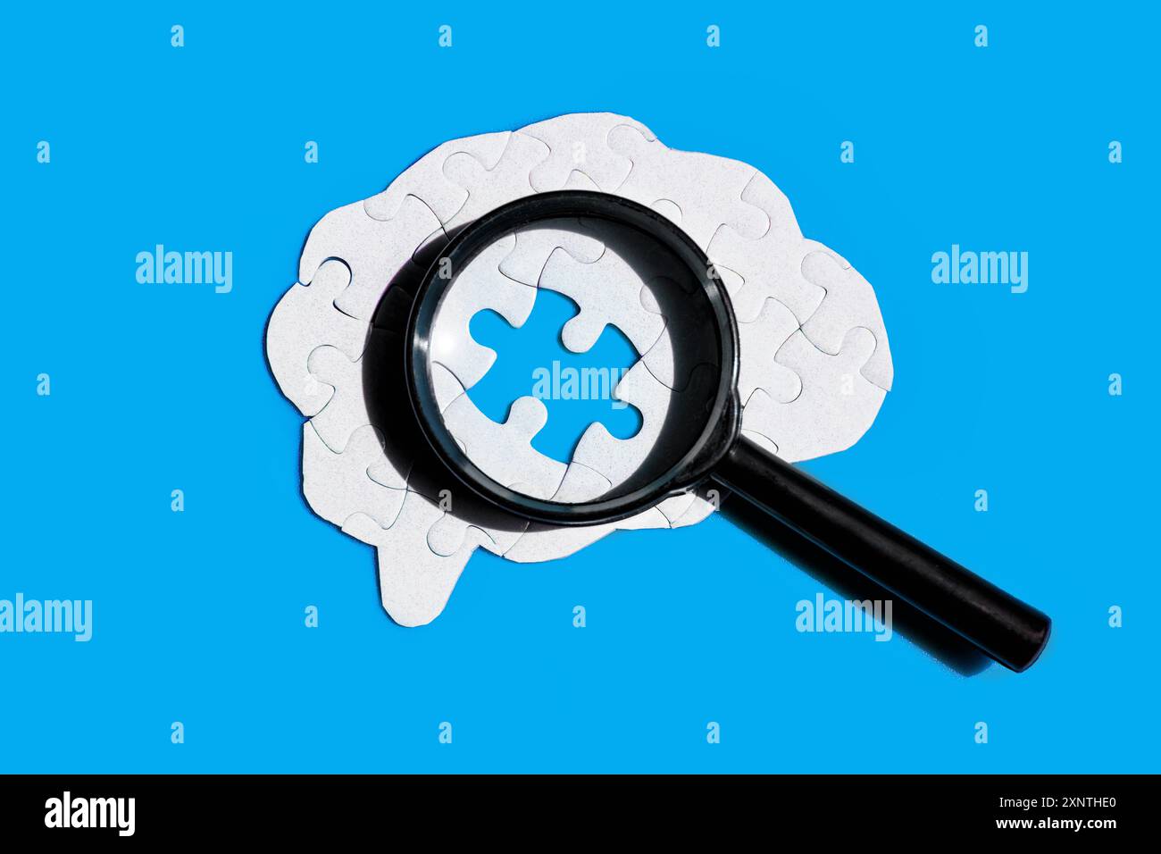 Close-up shot of magnifying glass over puzzle pieces resembling a human ...