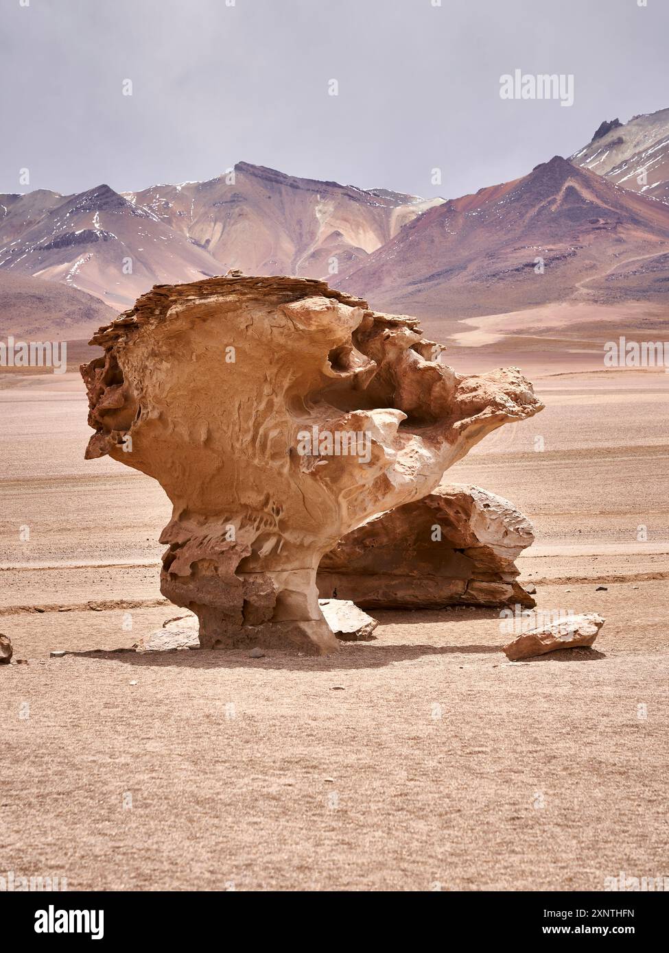 A stunning eroded rock formation set against majestic mountains in an ...