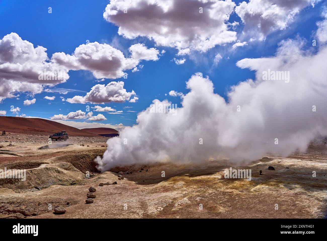 Off-road vehicle exploring an arid desert landscape with a prominent ...