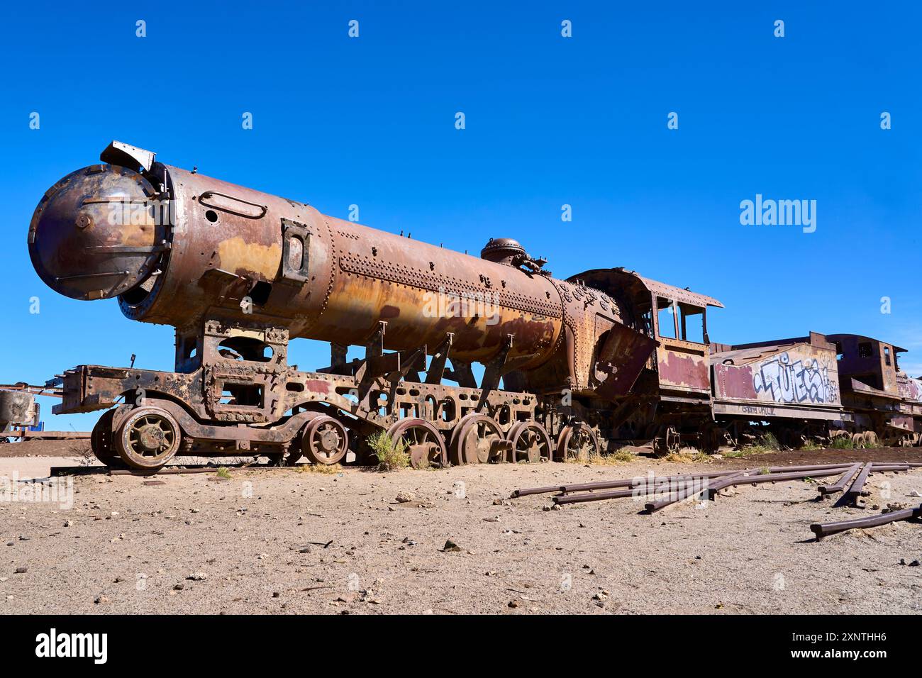 Rusty abandoned train locomotive in the Bolivian desert under a clear ...