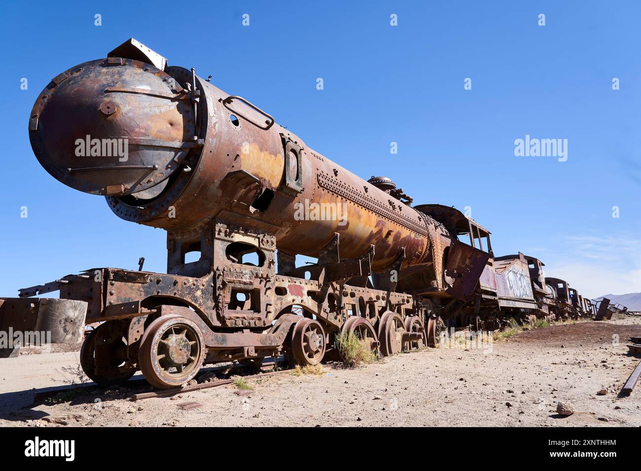 Rusty, abandoned trains in Uyuni's train cemetery under a clear blue ...