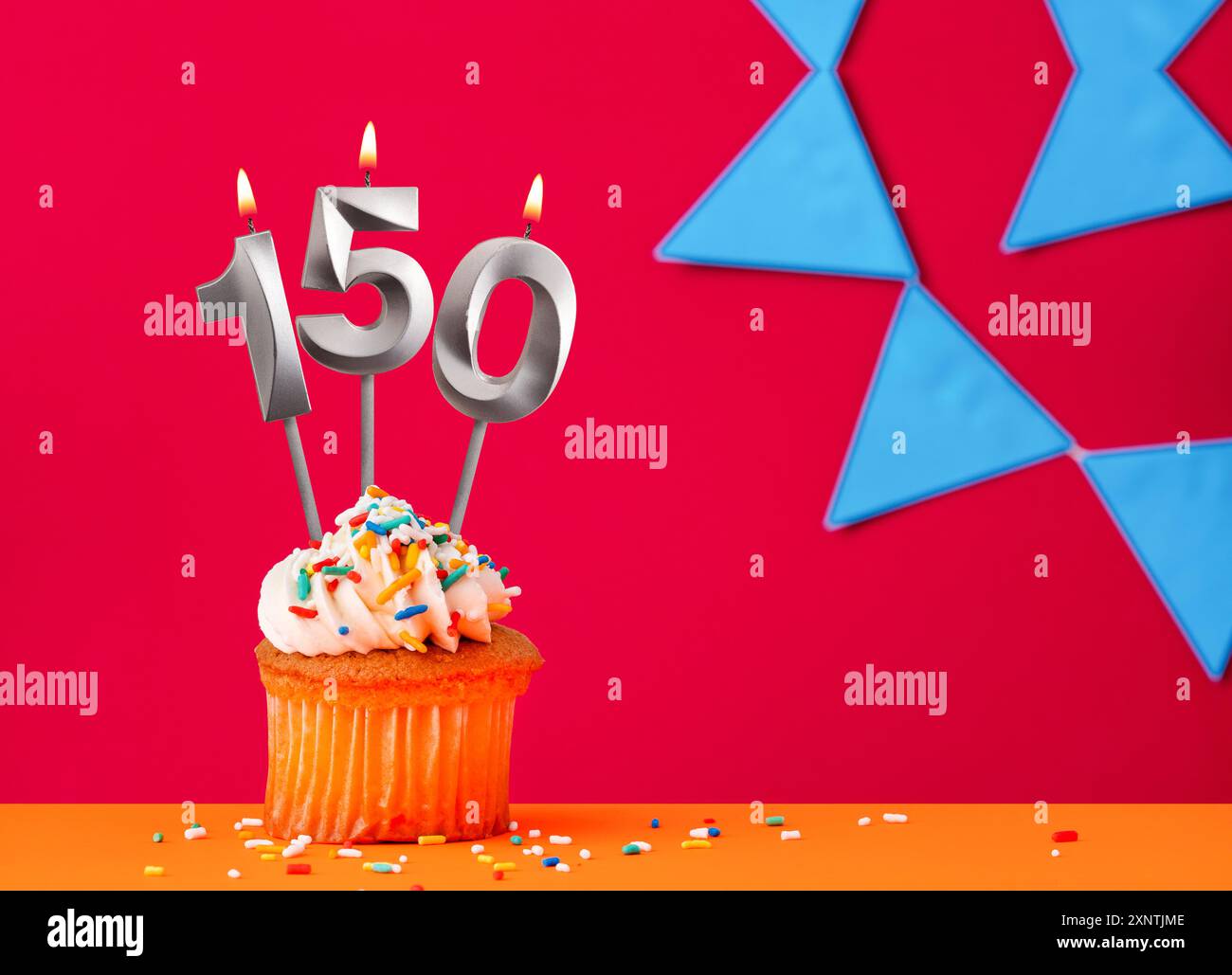Birthday cupcake with candle number 150 on a red background with blue ...