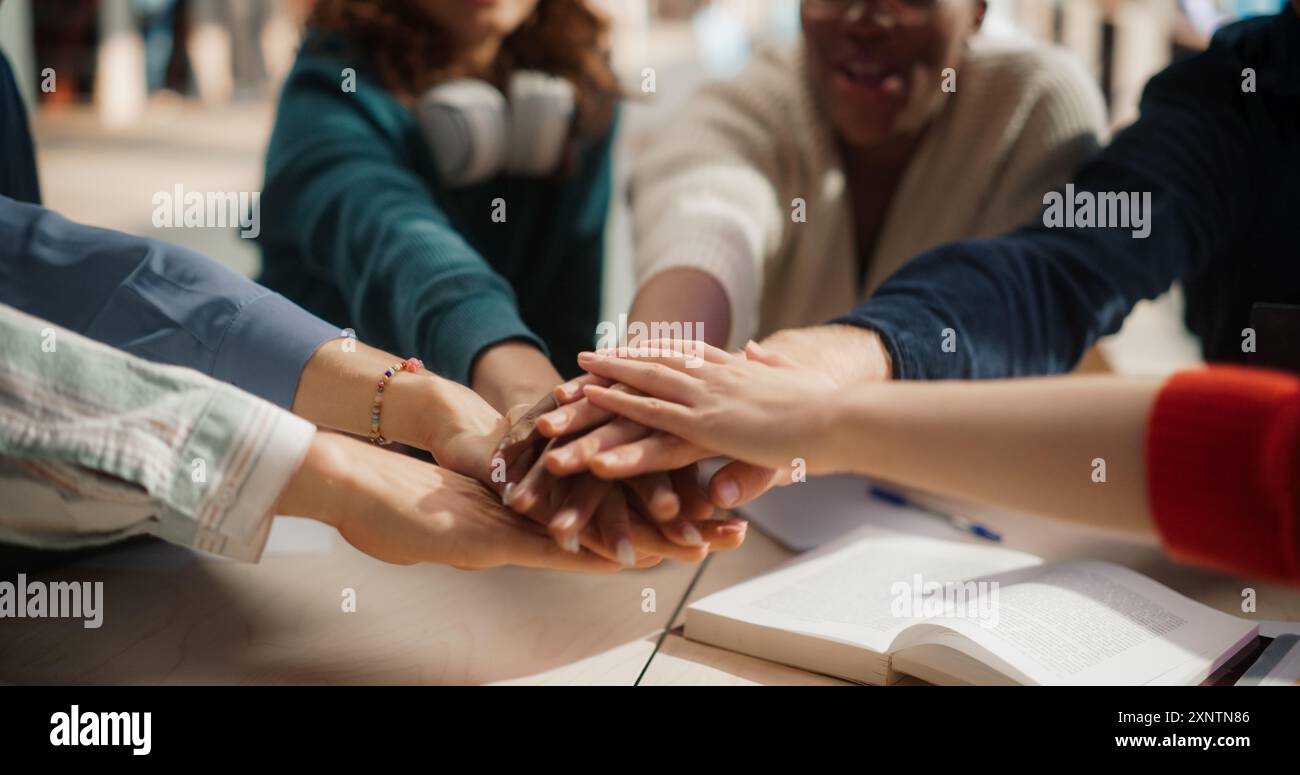 Diverse Group of Students Collaborating in a Library, Hands Joined in ...