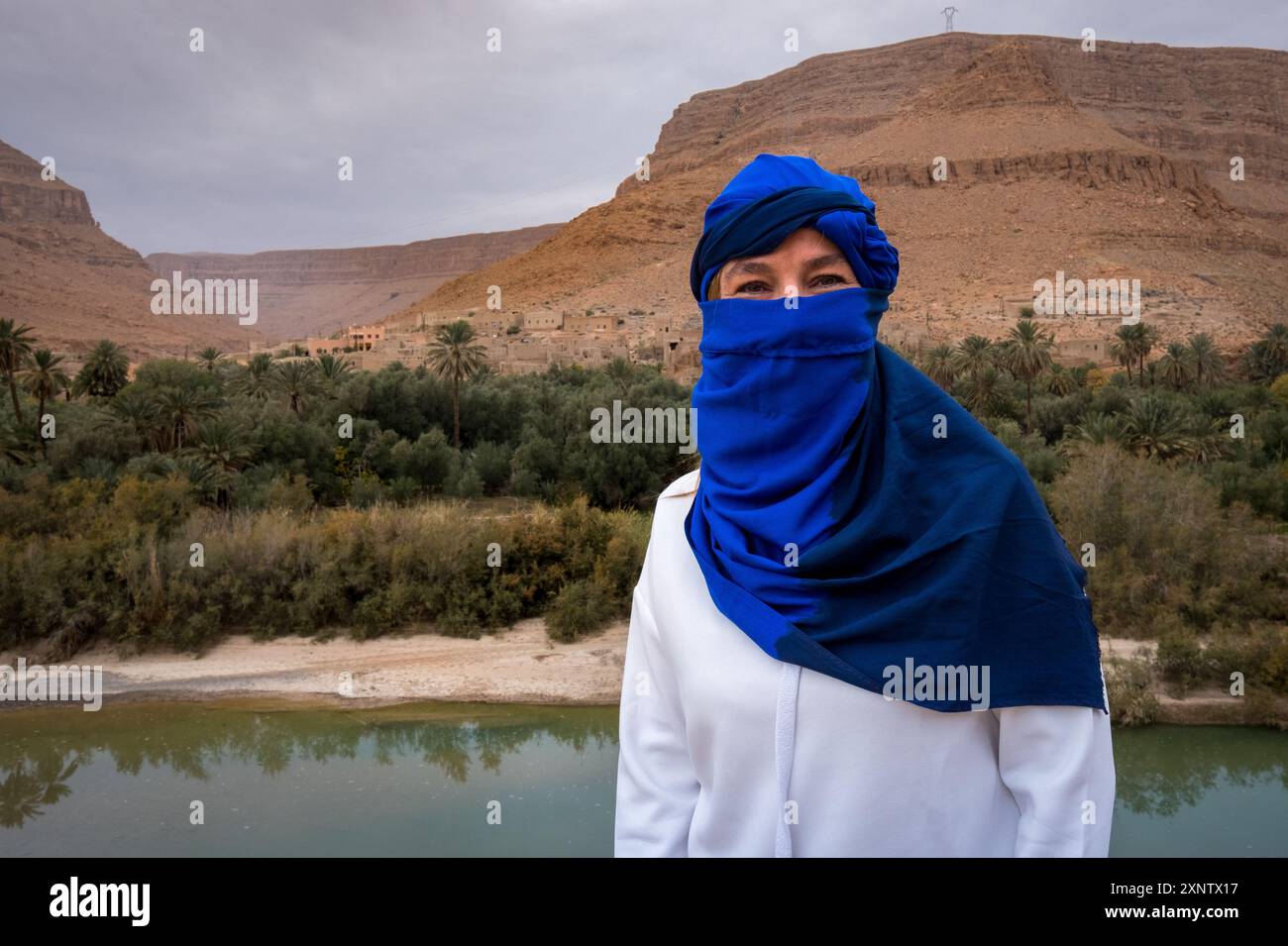 A beautiful woman poses with a blue touareg turban in front of the ...