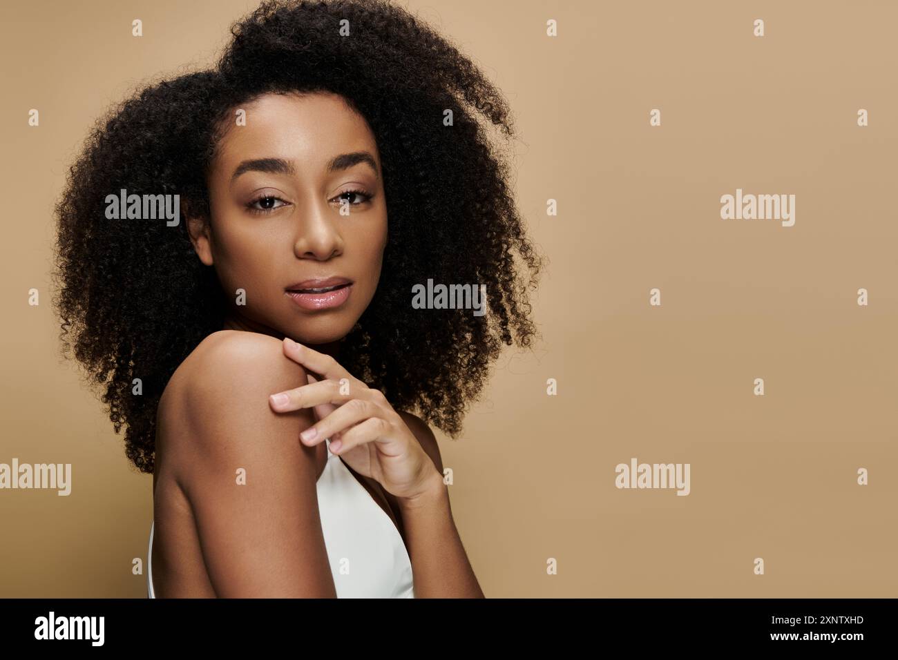 A beautiful African American woman with natural makeup poses against a ...
