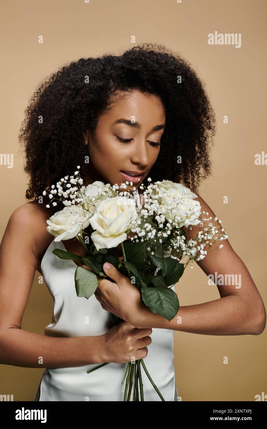 An African American woman with natural makeup holds a bouquet of white ...