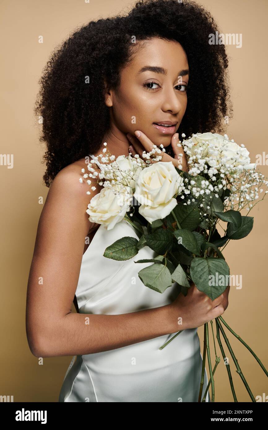 A beautiful African American woman with natural makeup holds a bouquet ...