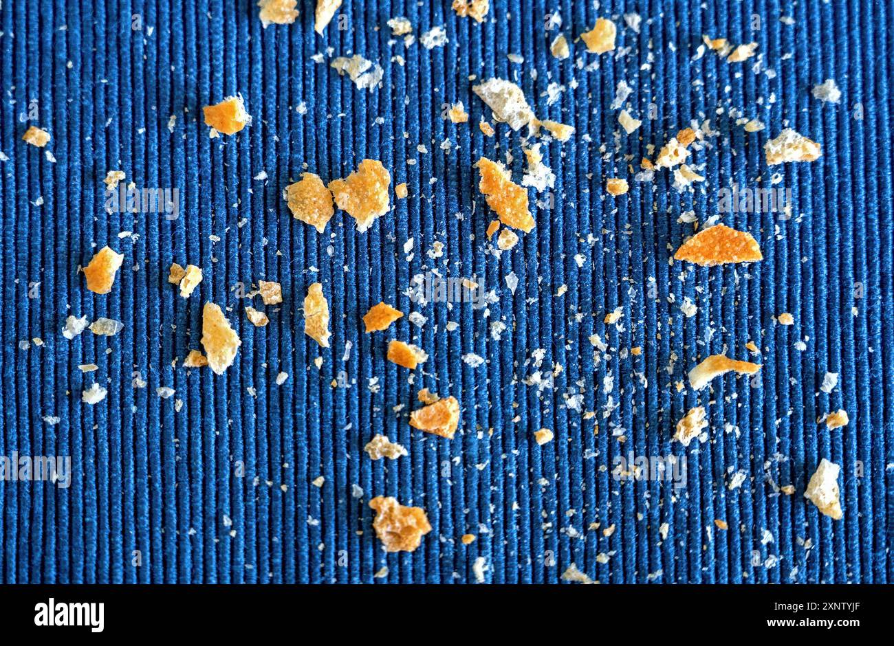 gold coloured crumbs of bread rolls on blue fabric Stock Photo - Alamy