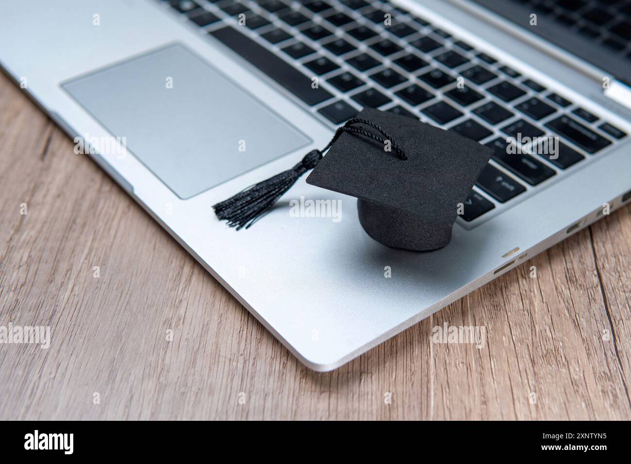 A graduation cap and a laptop. Copy space for text. Online learning and ...