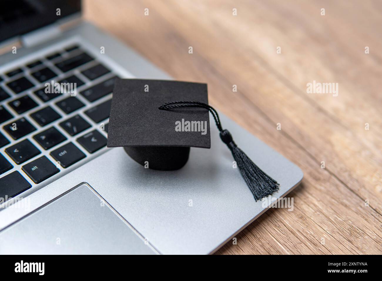 A graduation cap and a laptop. Copy space for text. Online learning and ...