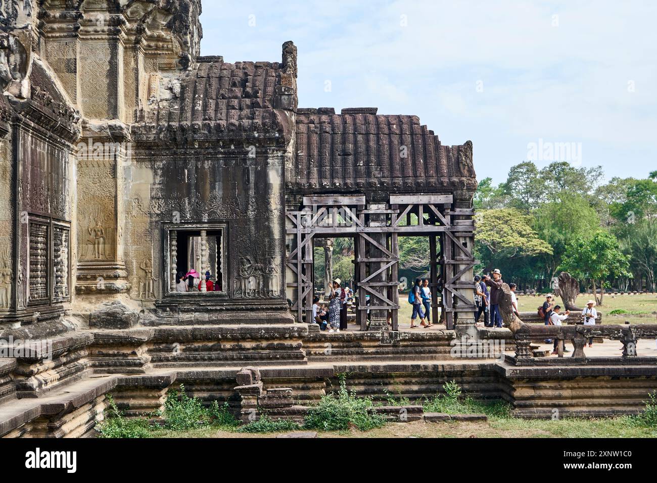 A group of tourists visiting the historic Angkor Wat temple complex in ...