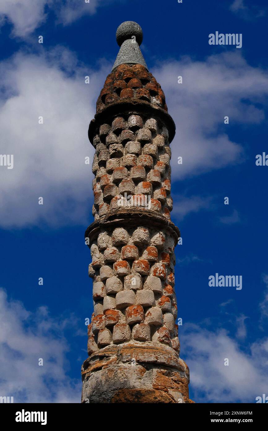 Finial of coursed rounded bricks at corner of stone wall surrounding ...