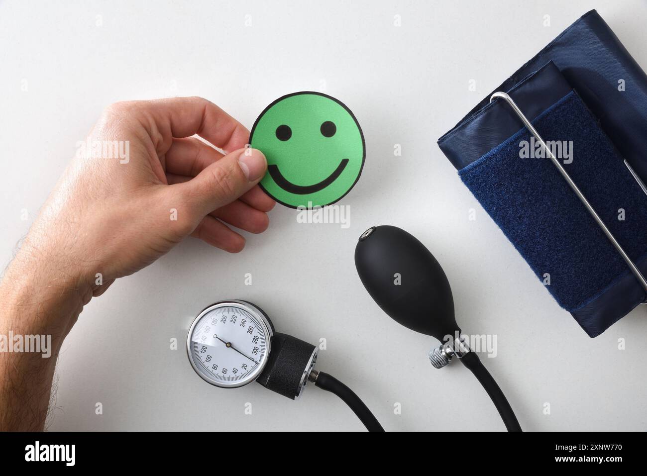 Concept of good blood pressure with hand holding cutout of smiling face ...