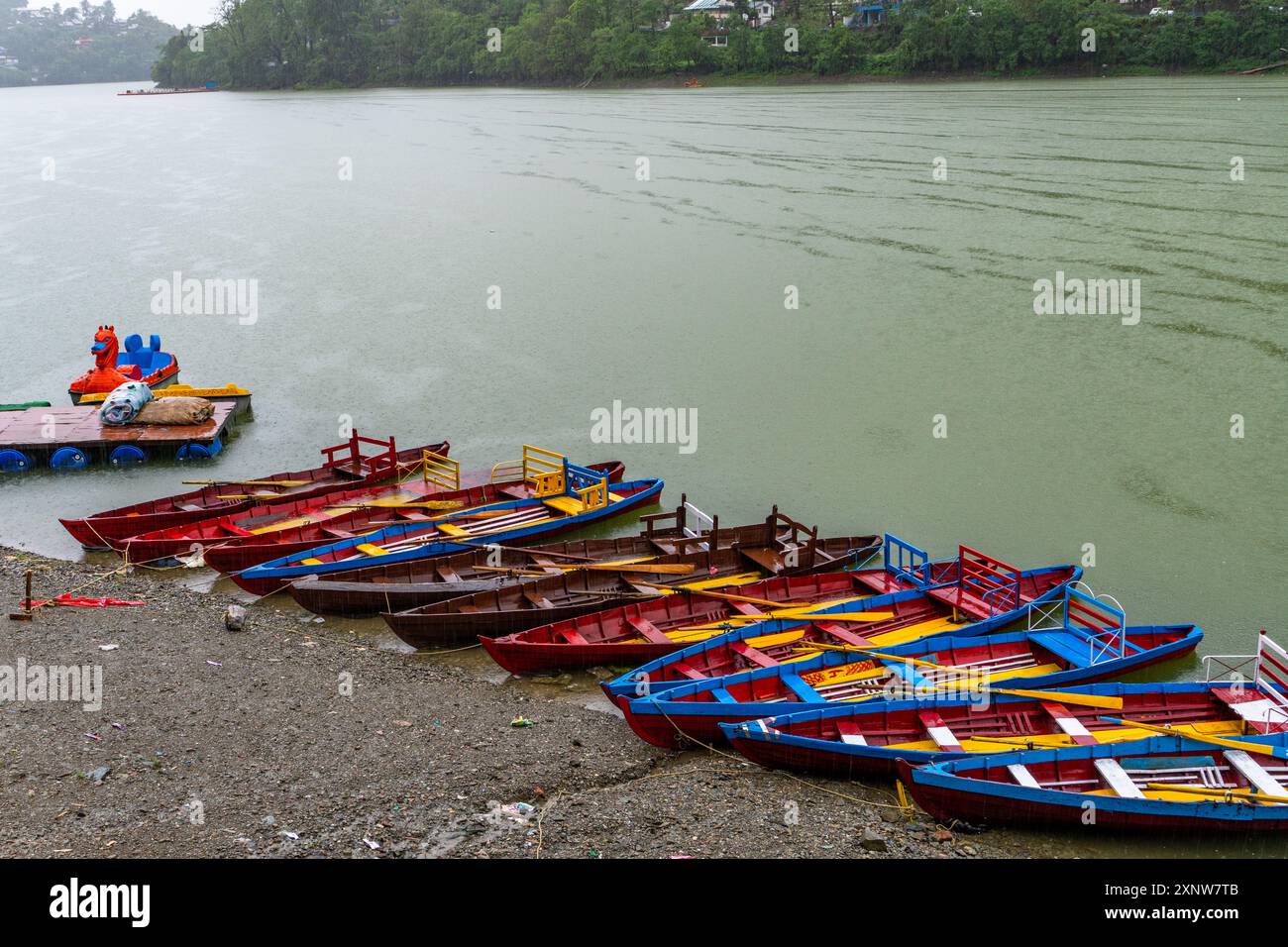 Empty boats lined up on the lakeside at Bhimtal Lake during the monsoon ...