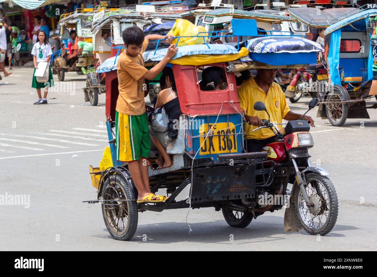 Passengers riding a tricycle, a popular public transport in the ...
