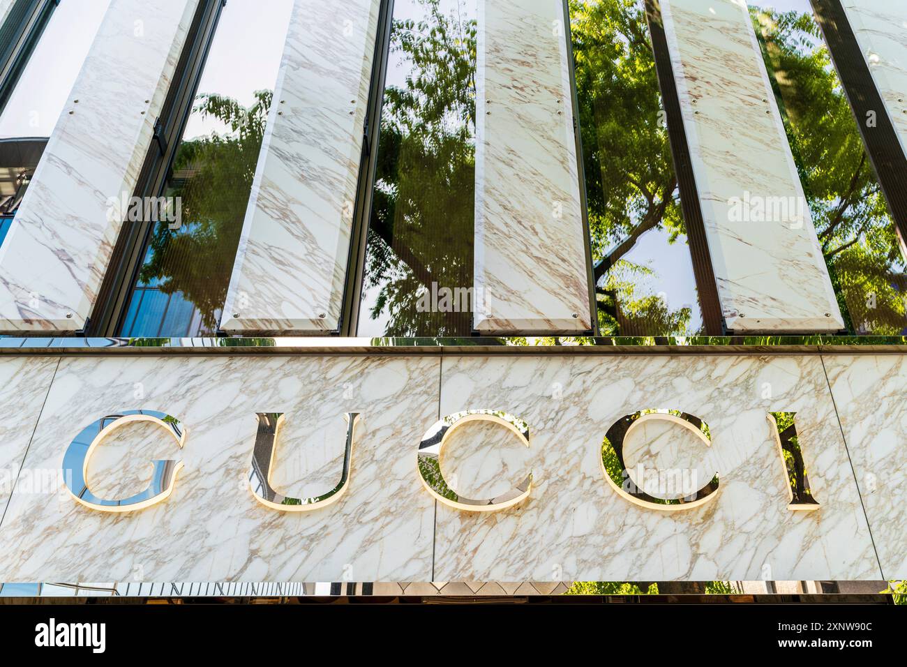 Gucci brand name in gold colour mirror letters on the marble facade ...