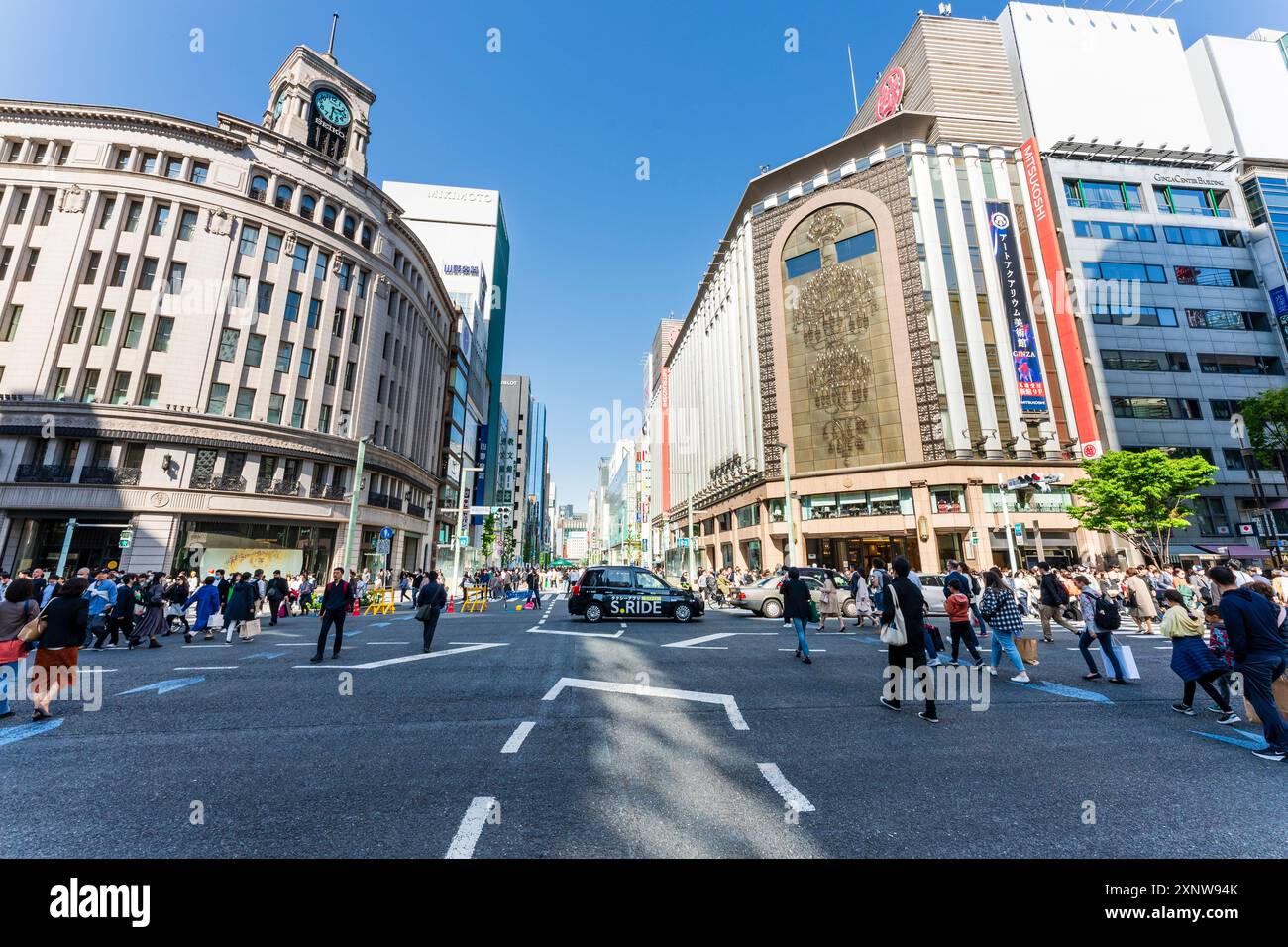 People crossing the the street at the Ginza crossroads with the famous ...