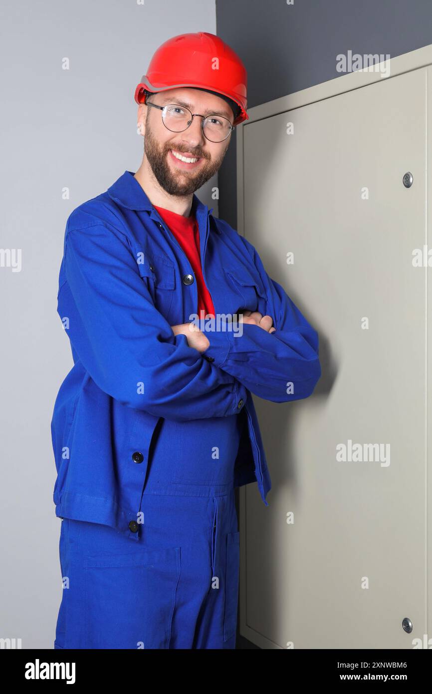 Happy electrician wearing uniform near electric meter box Stock Photo ...