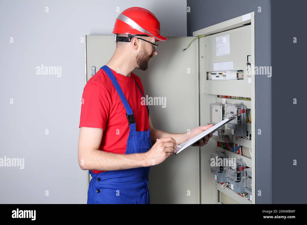 Technician worker with clipboard inspecting electricity meter Stock ...