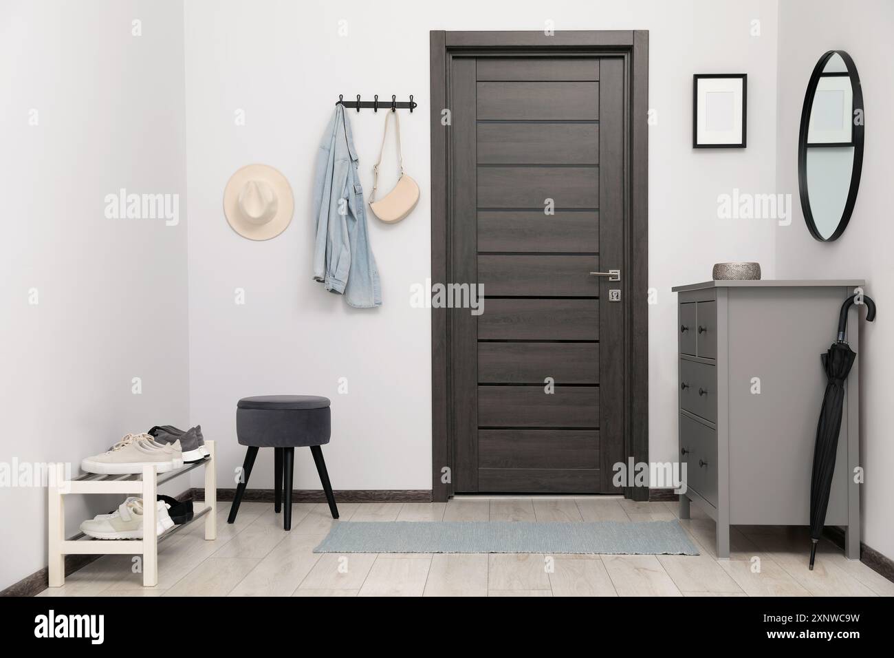Chest of drawers, mirror and shoe storage bench in hallway. Interior ...