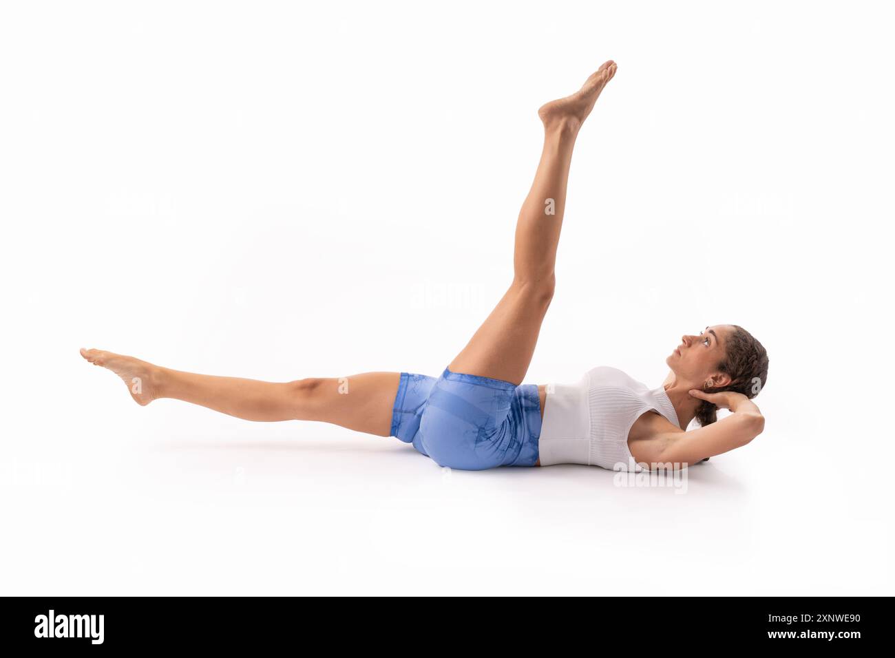 Woman performing challenging yoga leg raise, demonstrating core ...