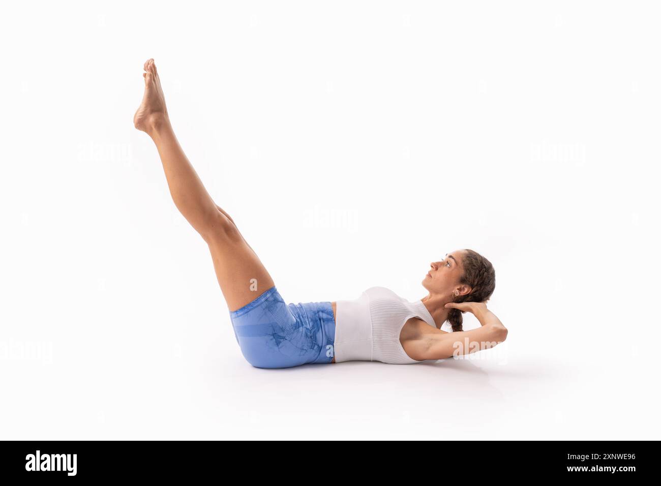 Woman performing yoga leg raise variation. Demonstrating core strength ...