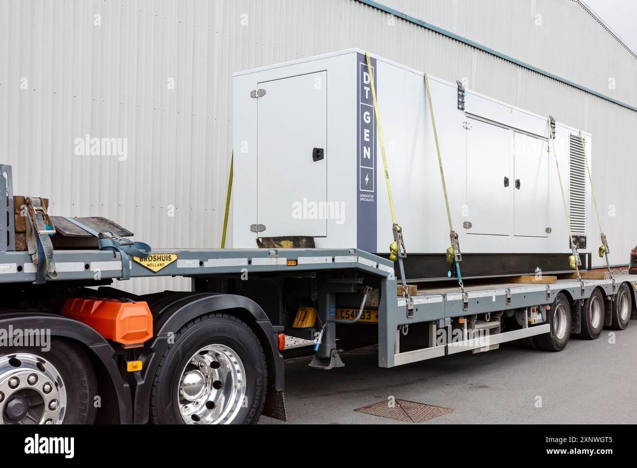 Heavy-duty generator being transported on a flatbed truck outside an ...
