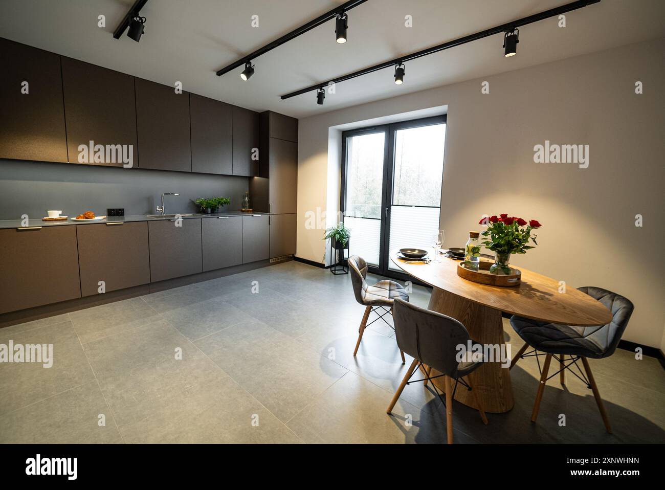 Dining table with plates, glasses and vase of red roses. Interior of a ...
