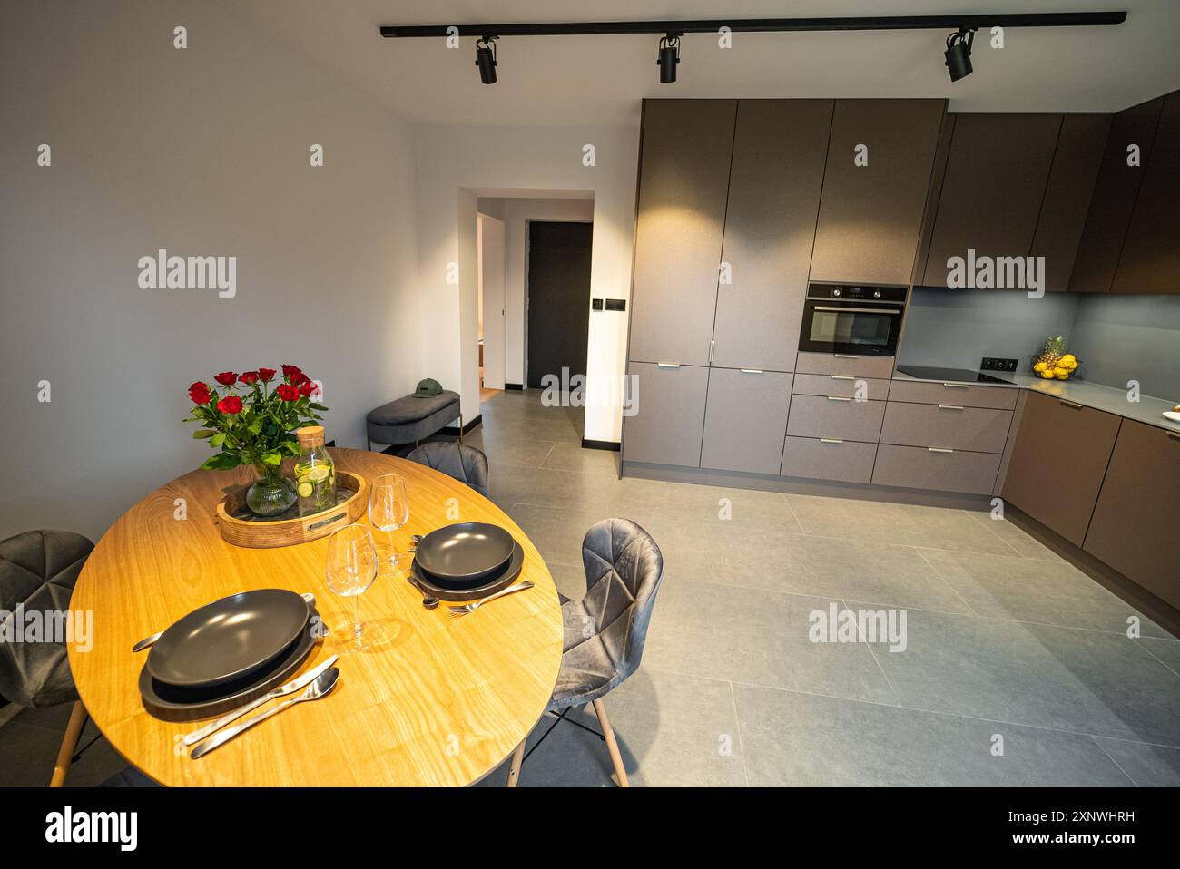 Dining table with plates, glasses and vase of red roses. Interior of a ...