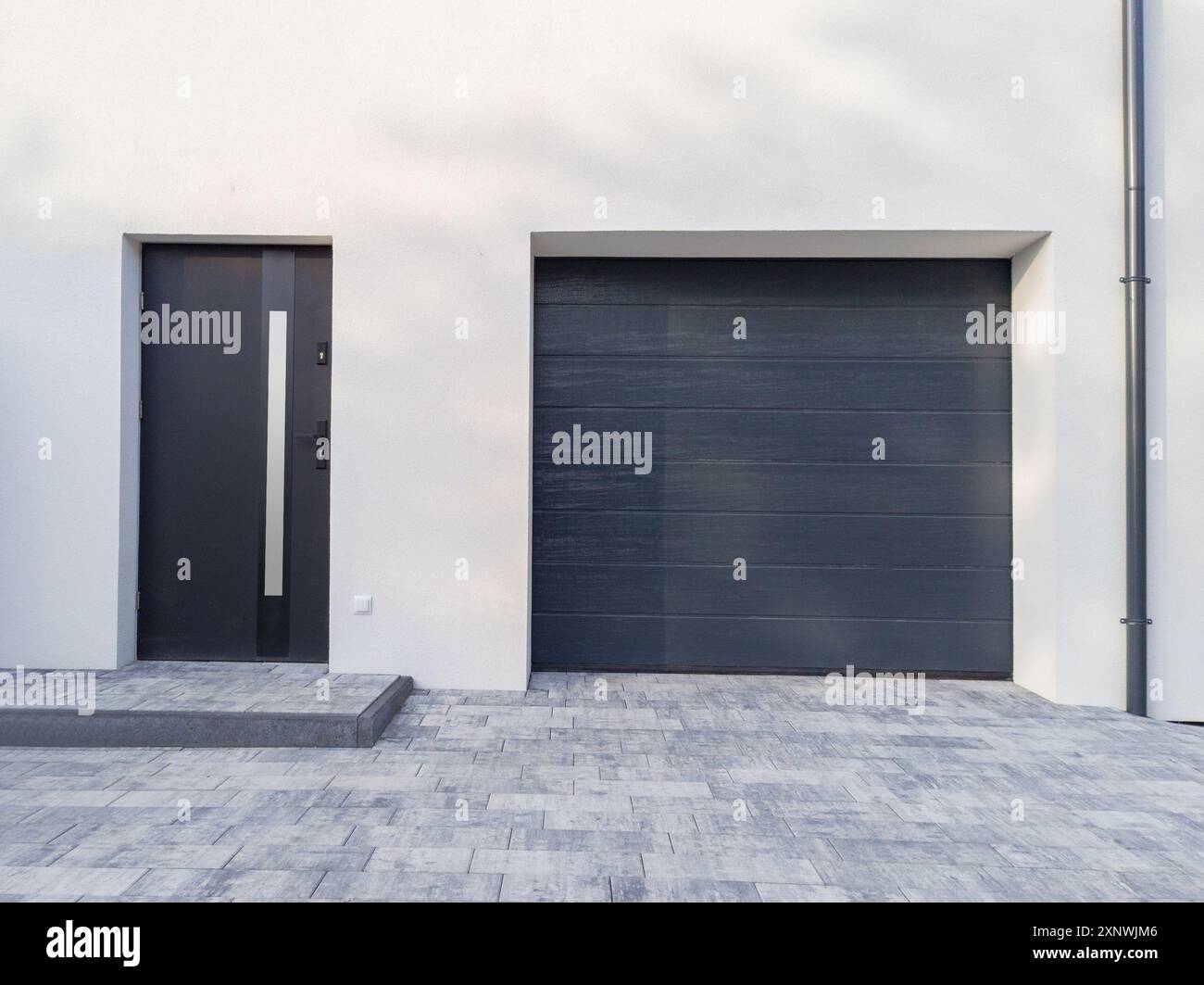 Modern House Entrance with Dark Garage Door Stock Photo - Alamy