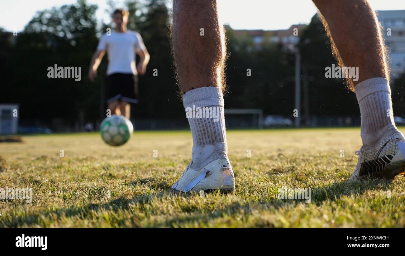 Male feet of professional footballers passing soccer ball on stadium at ...