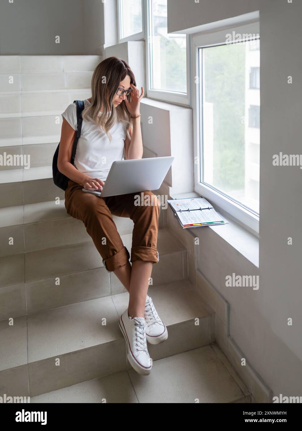 Thoughtful woman looks in notepad with handwriten notes. Student is ...