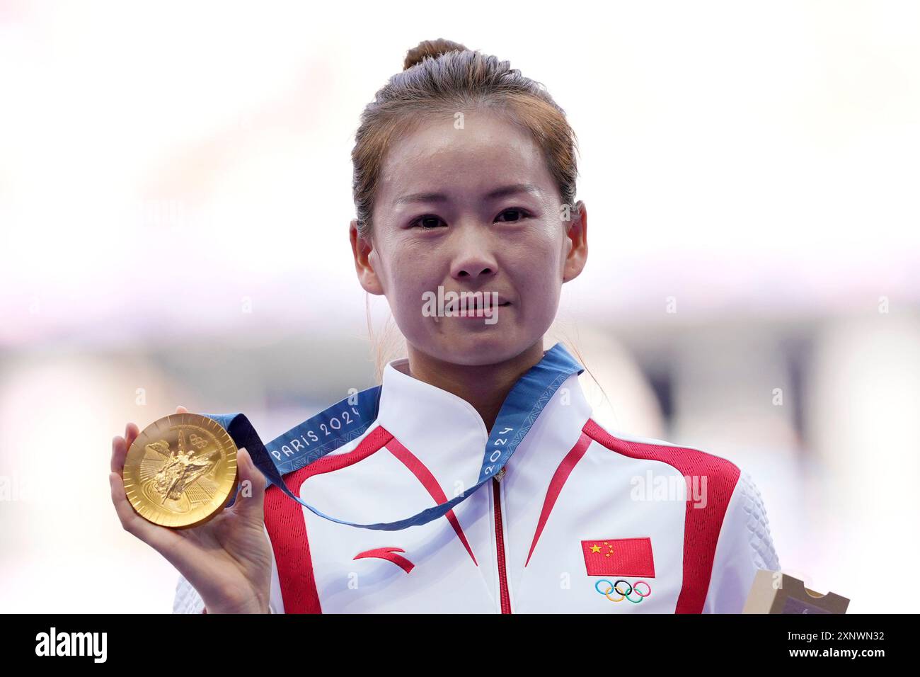 Tears roll down the face of Jiayu Yang, of China, as she poses on the podium after winning the ...