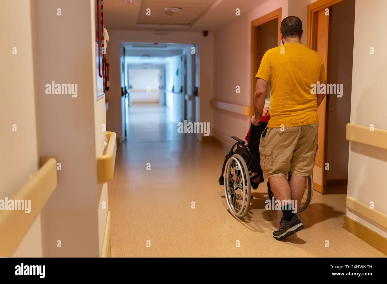 A long corridor where an elderly man and woman walk in their ...