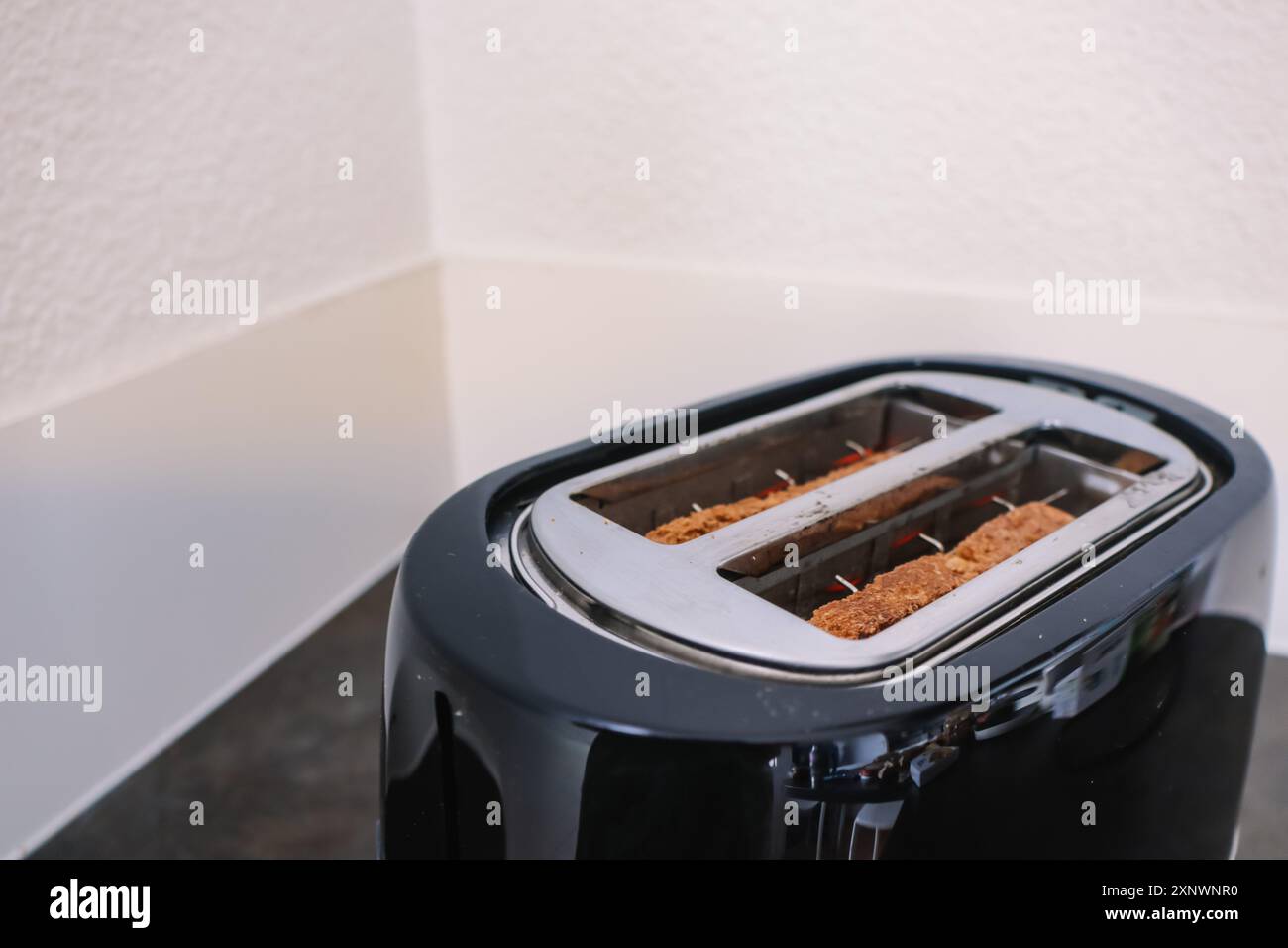 Black toaster in operation with two slices of bread inside in the ...