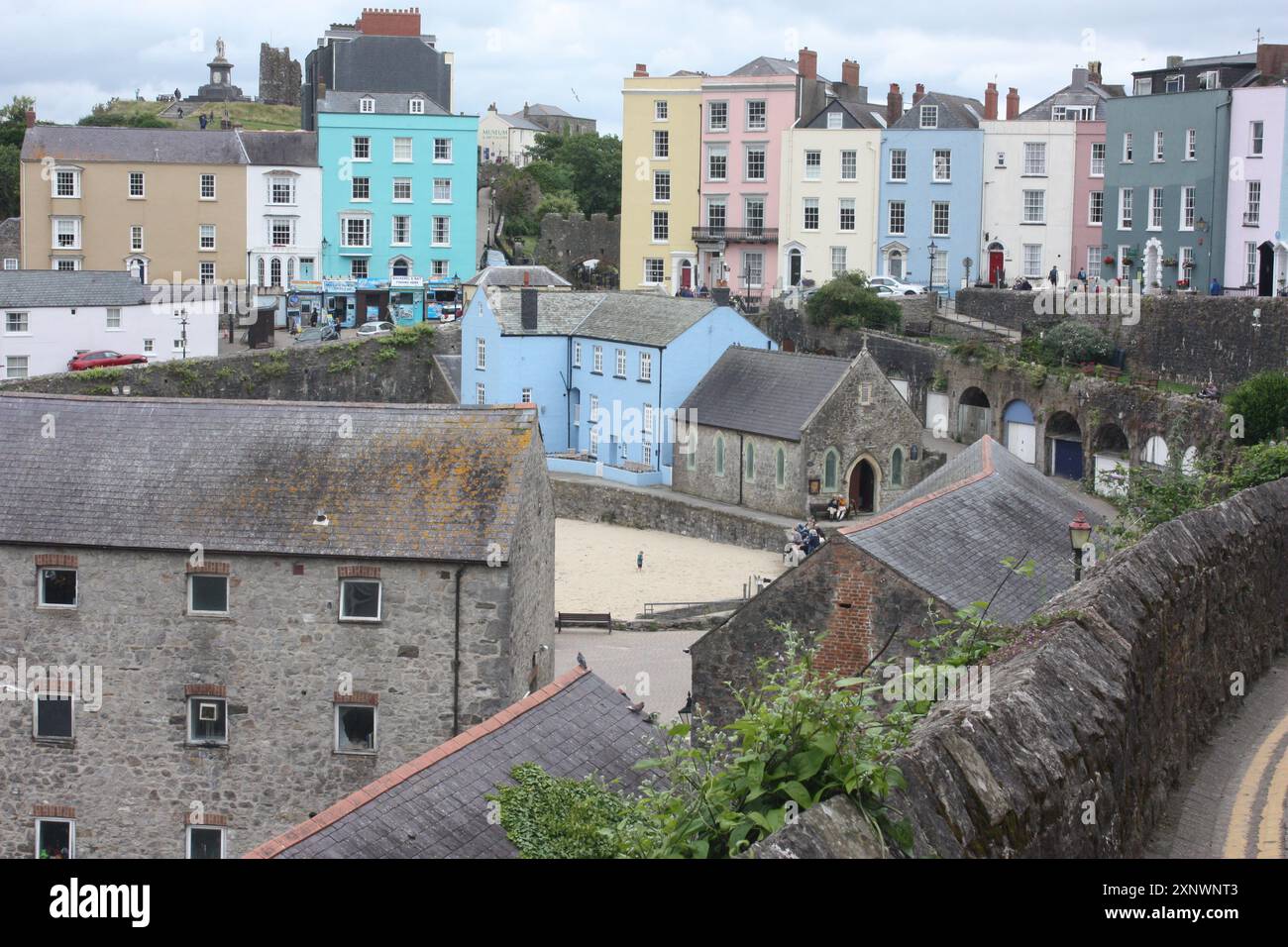 Pastel-coloured houses around the harbour in Tenby, South Wales, UK ...