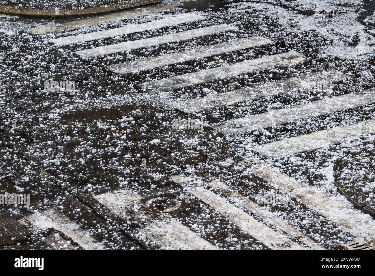 A general view of the hail on the road is seen after a hail storm Stock ...