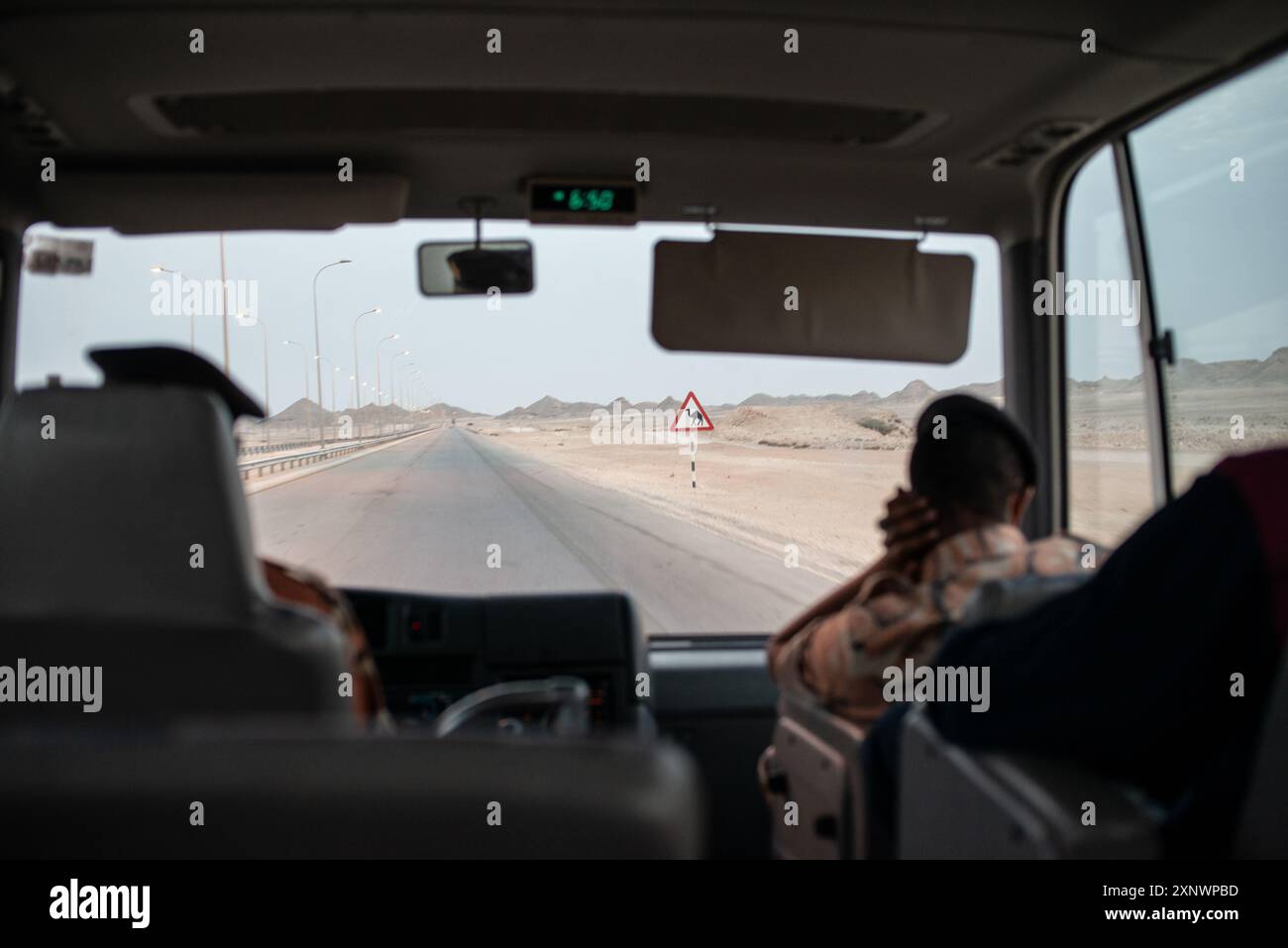 Shot of a bus interior with a view of a desert road and a camel sign ...