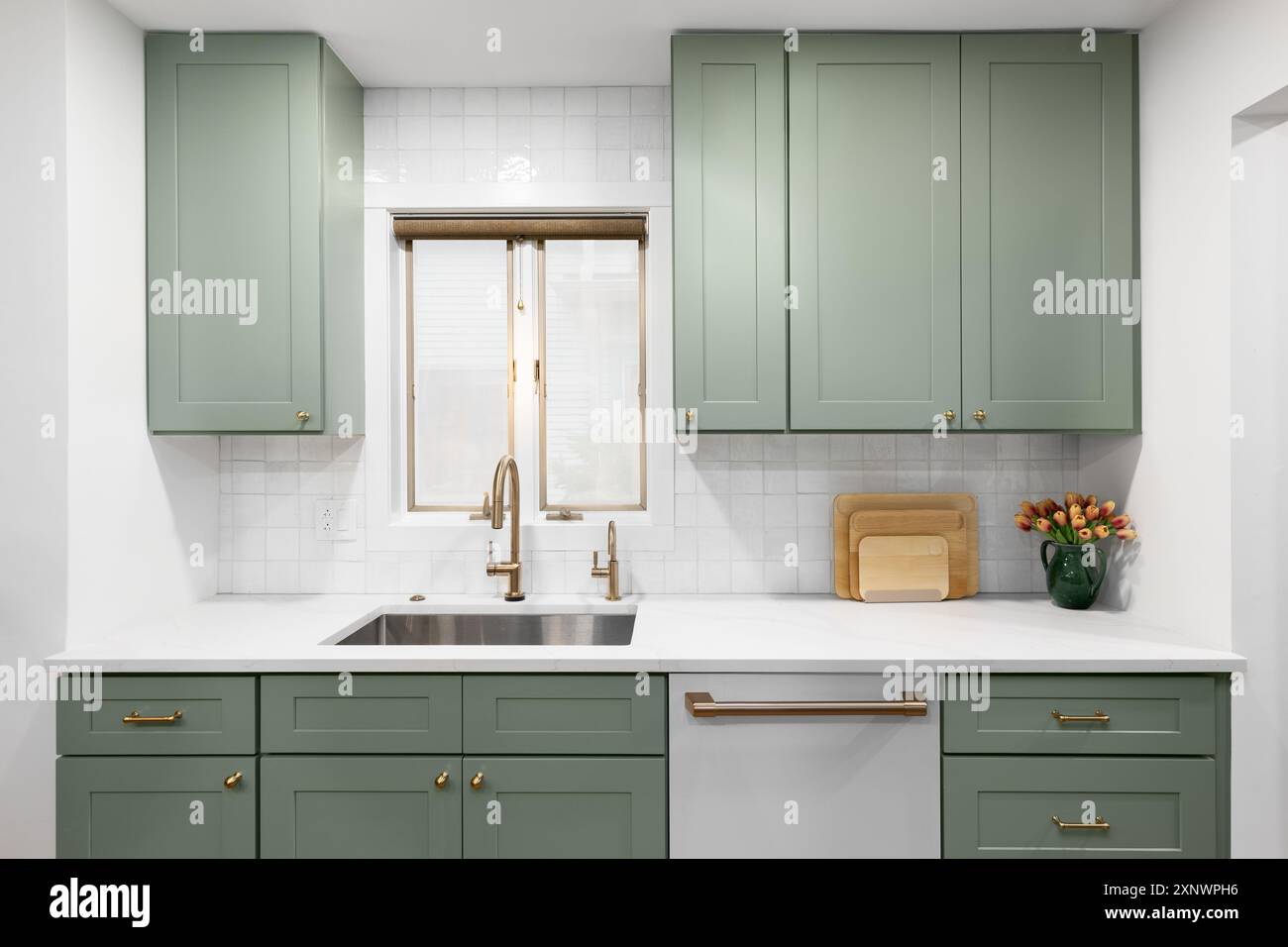 A kitchen detail with sage green cabinets, white marble countertop ...