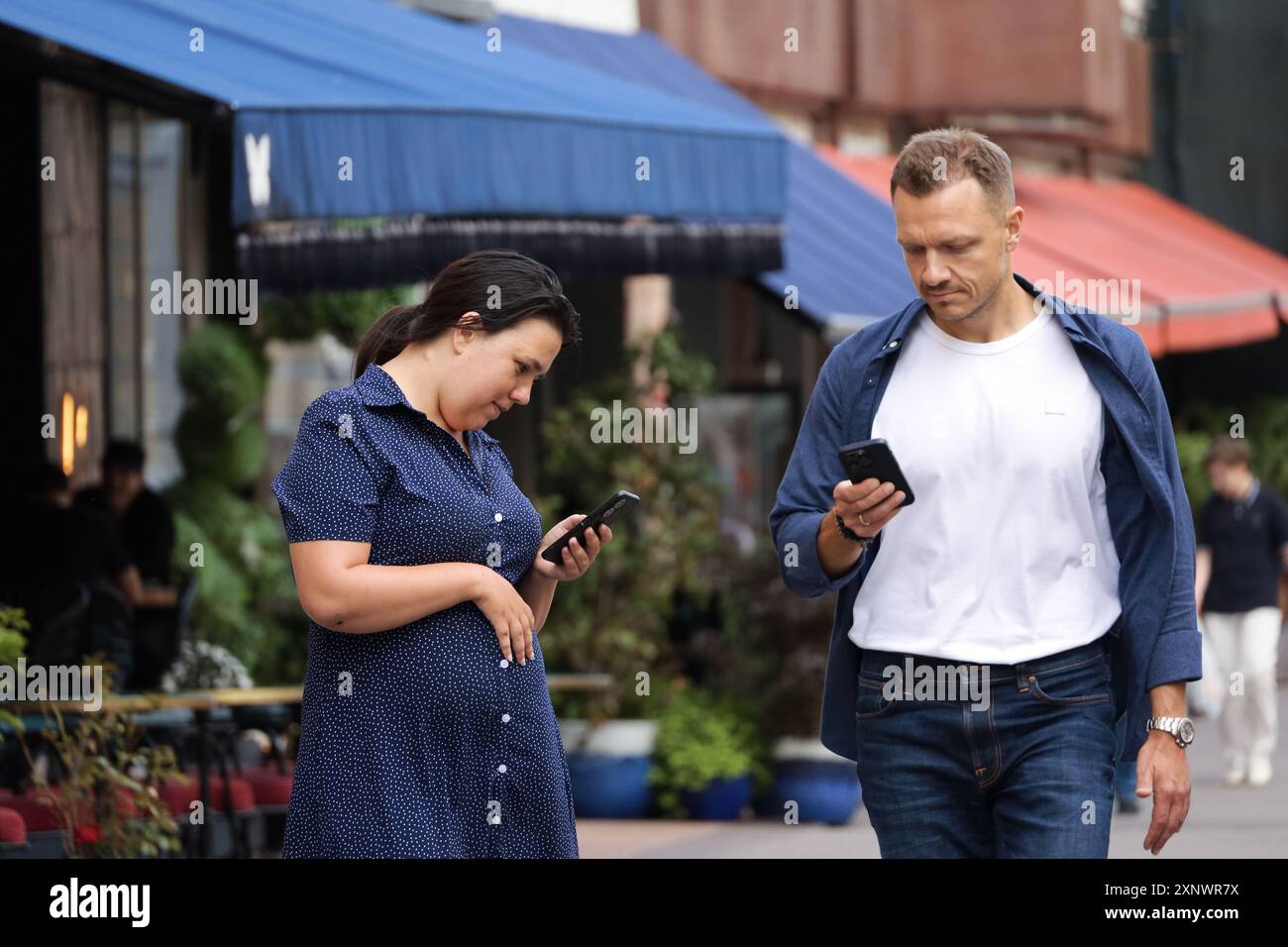 People using smartphones on a street in summer city Stock Photo - Alamy