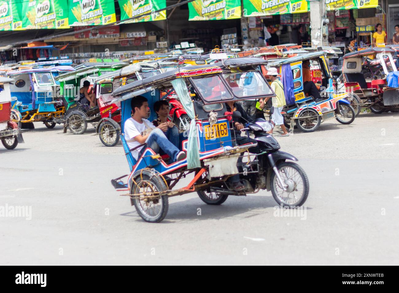 Passengers riding a tricycle, a popular public transport in the ...