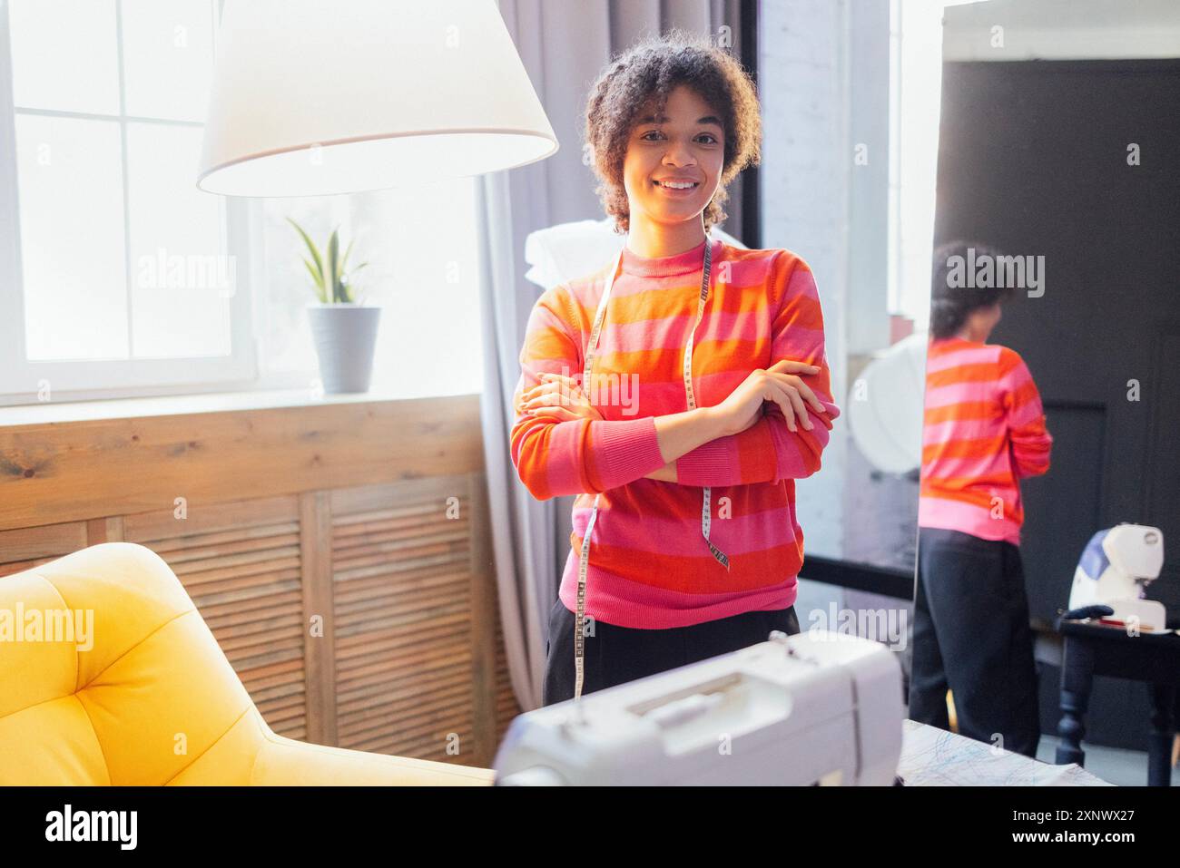 Young laughing African woman stands next to dressmaker mannequin ...