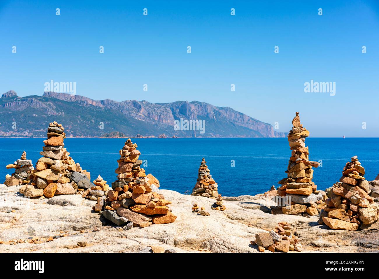 Rock towers with coastal landscape of Sardinia in the background ...