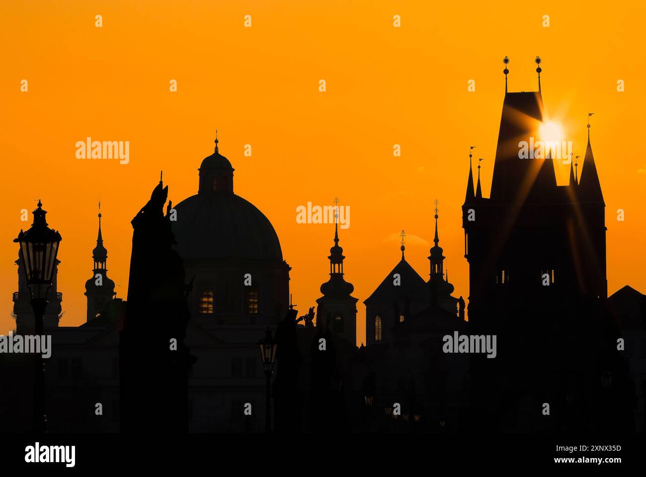 Sun rising above silhouettes of towers and spires at Charles Bridge at ...