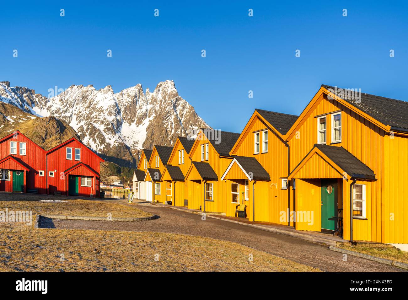 Traditional wooden and colorful buildings surrounded by snowy mountains ...