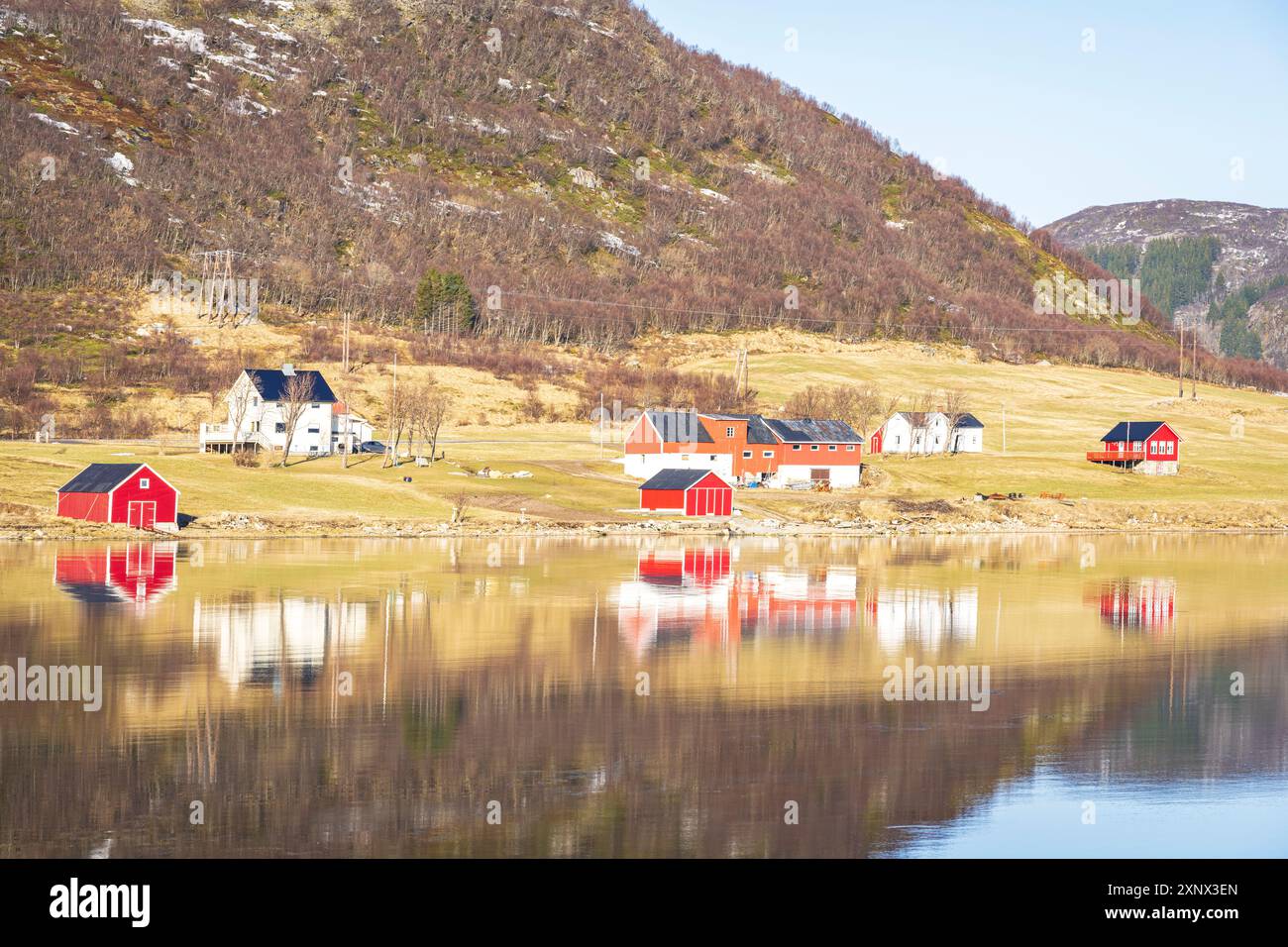 Rural scene of typical buildings and wooden hills by the fjord with ...