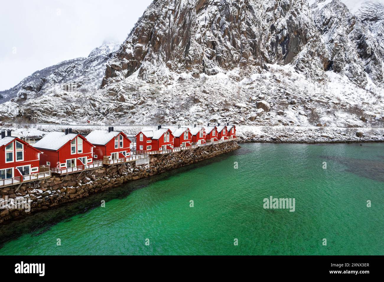 Typical wooden rorbu in winter scenery by the emerald water of the ...