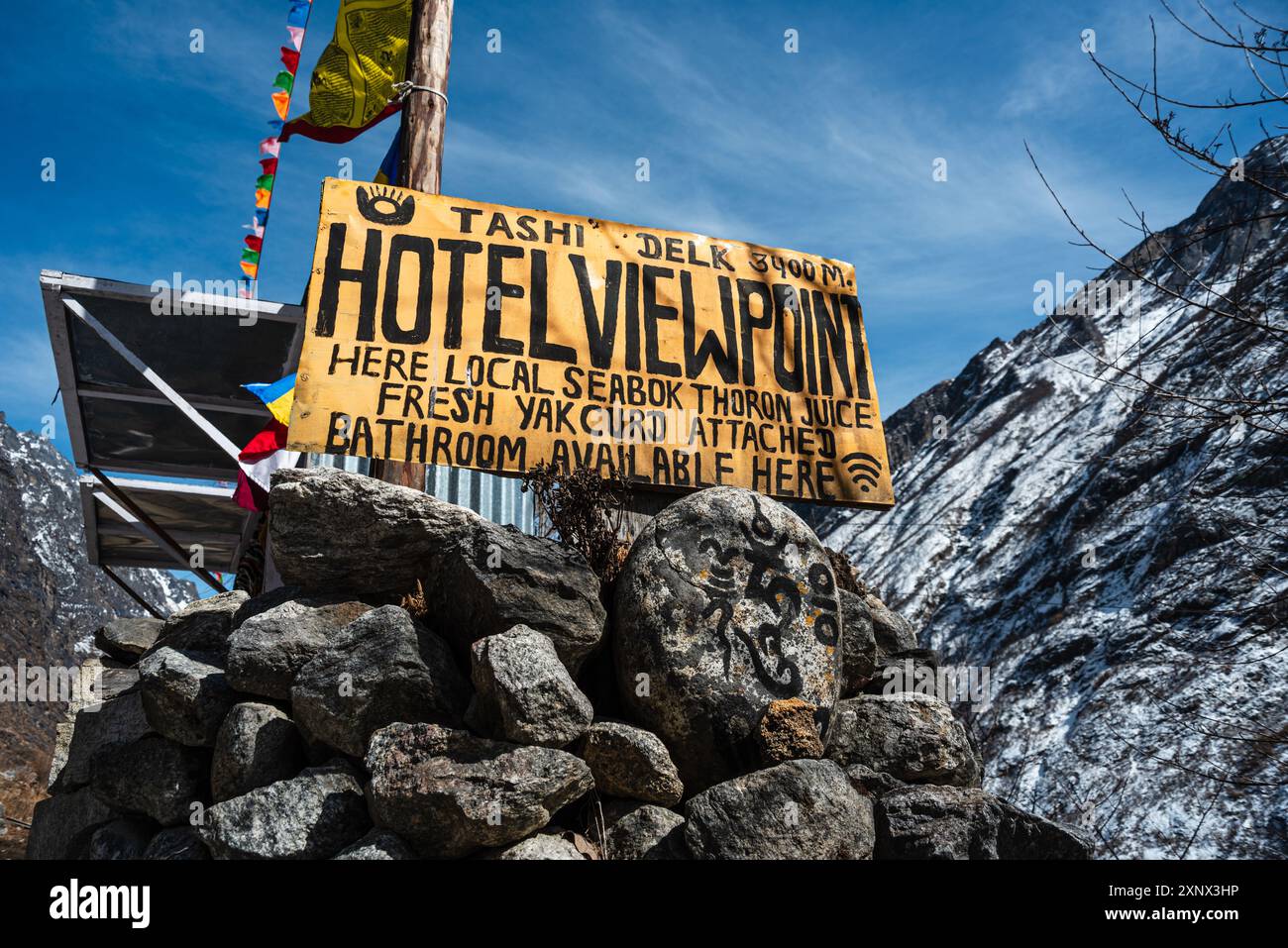 Yellow Hotel Sign on rocks in front of mountain slopes, Langtang Valley ...